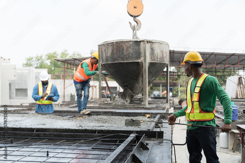 Construction workers pouring wet concrete by concrete bucket for ...