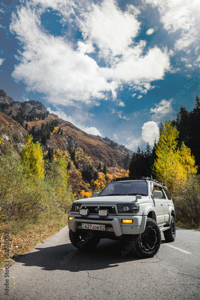 Off-road white 4x4 car Toyota Hilux Surf on autumn mountain road trip ...