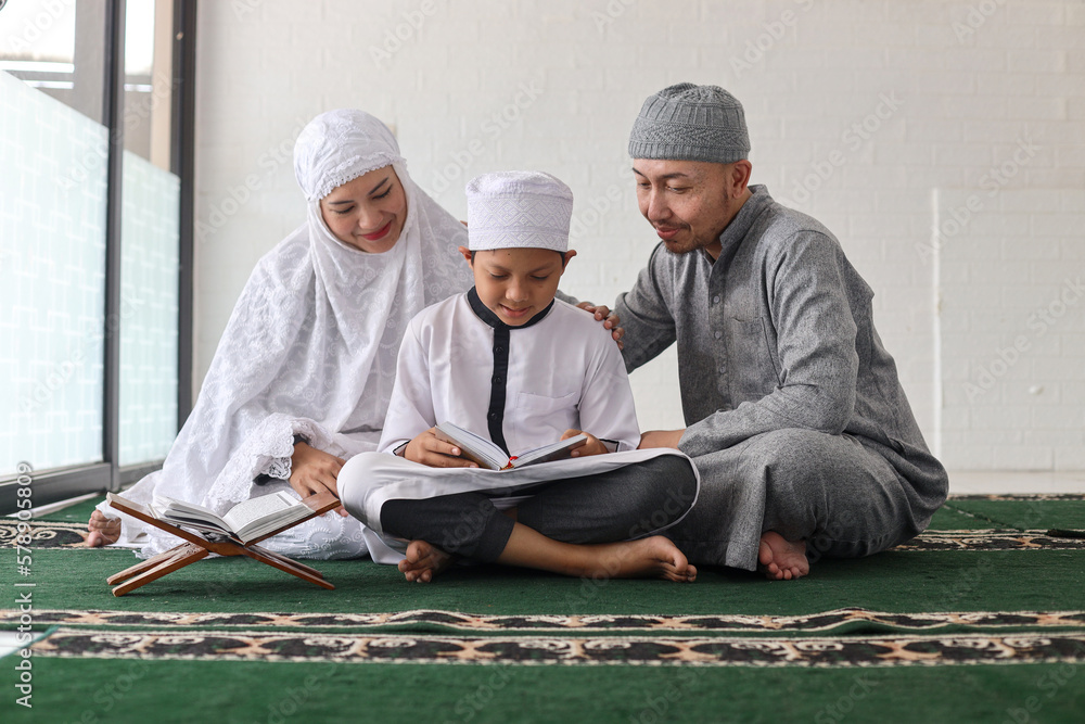 Traditional muslim family parents with children reading Quran and ...