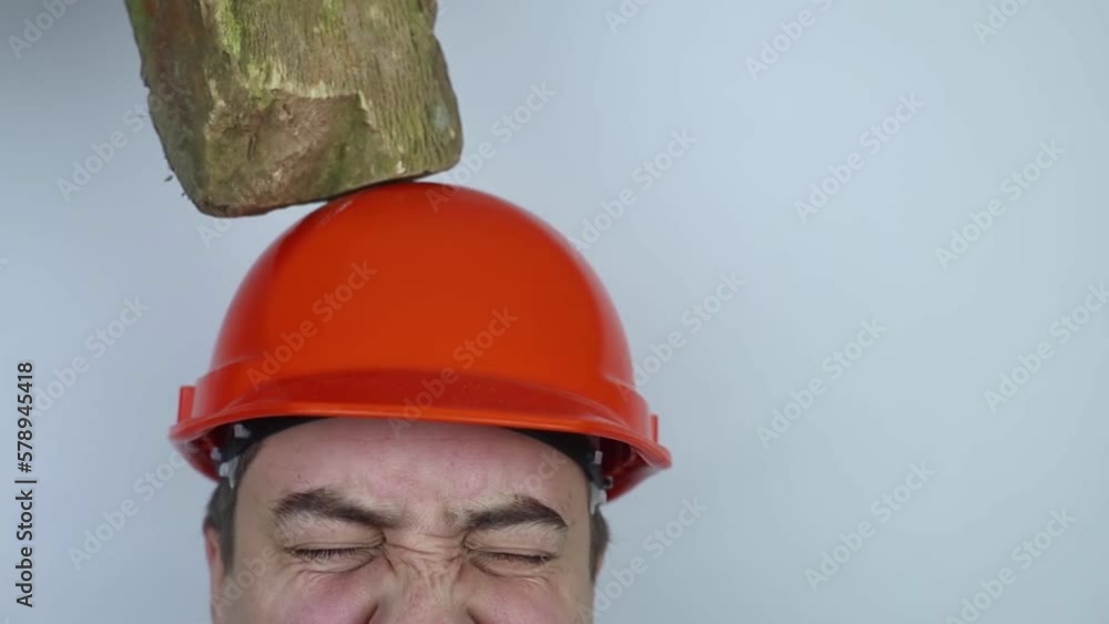 Safety helmet. Brick and a board fall on builder head. Saving a life ...