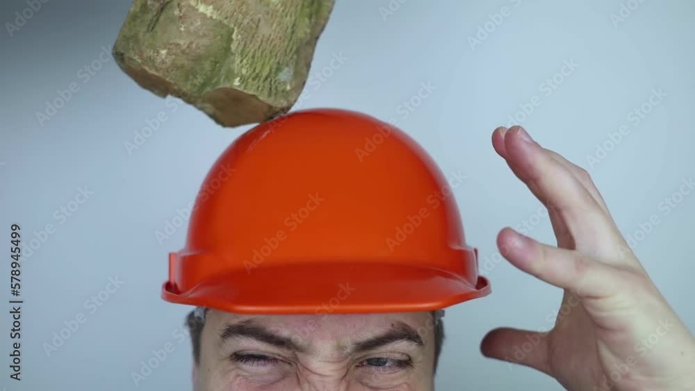 Safety helmet. Brick and a board fall on builder head. Saving a life ...