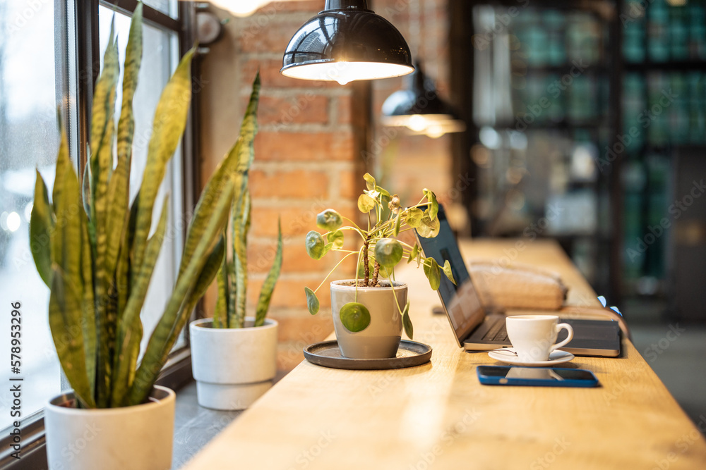 Workplace with laptop and coffee drink on shared table by the window at ...