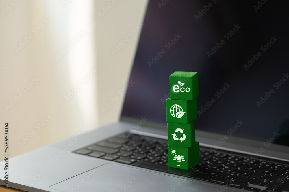 Technology with nature concept.Green wooden cube with icons on laptop keyboard. Carbon efficient ...