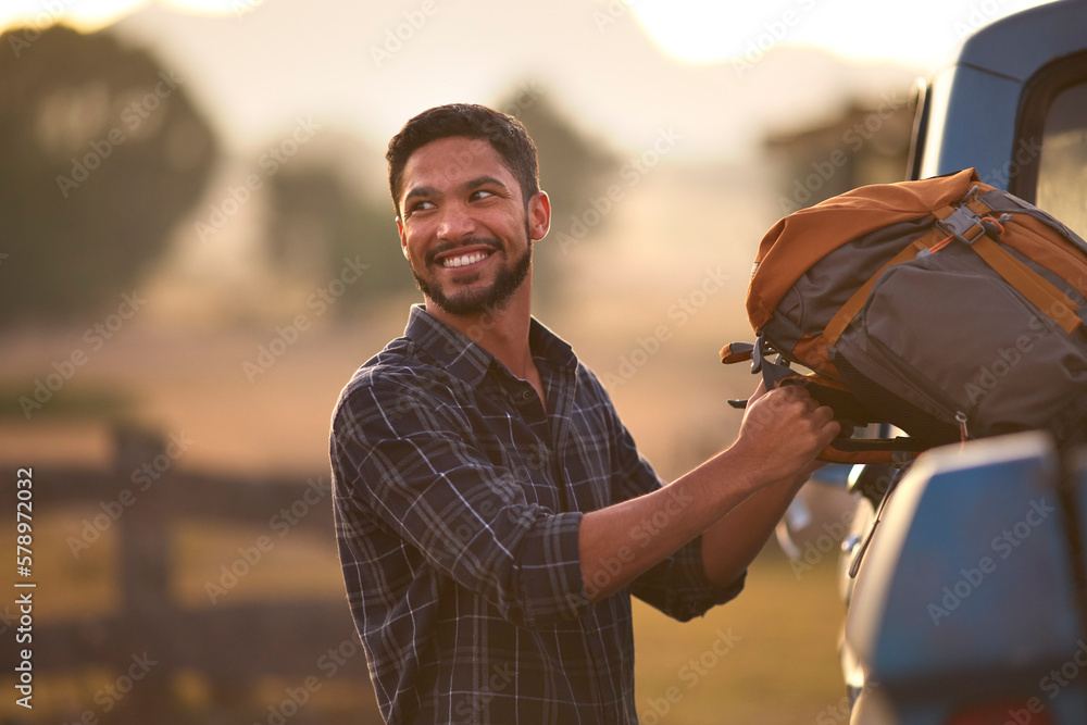 Man Loading Backpack Into Pick Up Truck For Road Trip To Cabin In ...