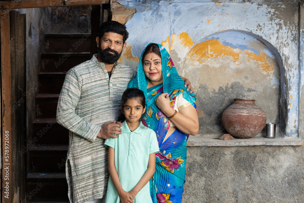 Rural indian parents with girl child. Happy young family looking at ...