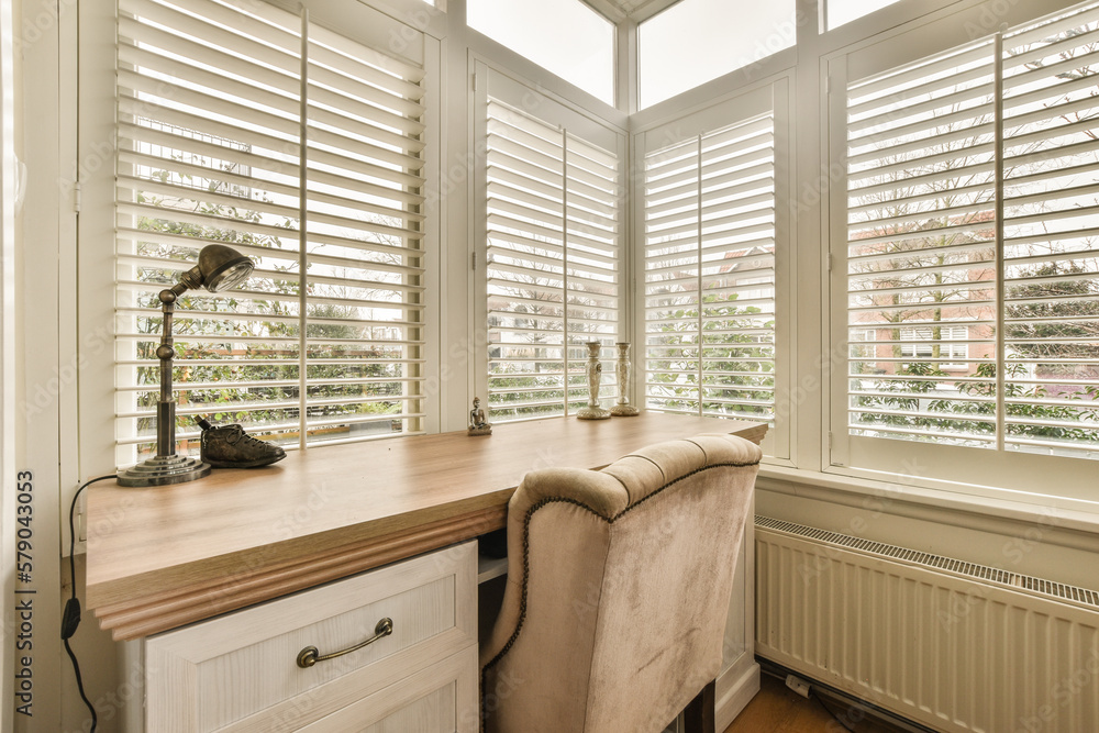 a window with shutters on the outside and an office desk in the middle ...