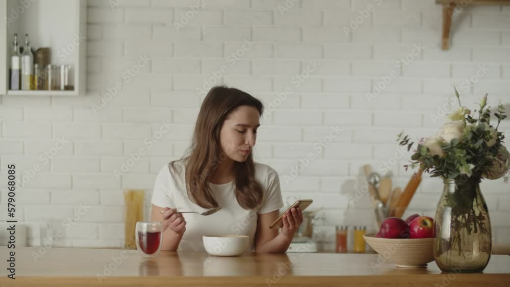 Video of a woman eating oatmeal for breakfast while sitting in the ...