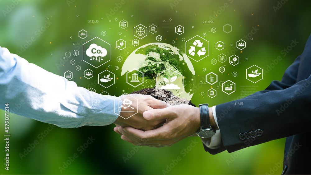 environment earth day In the hands of a businessman handing a planted ...