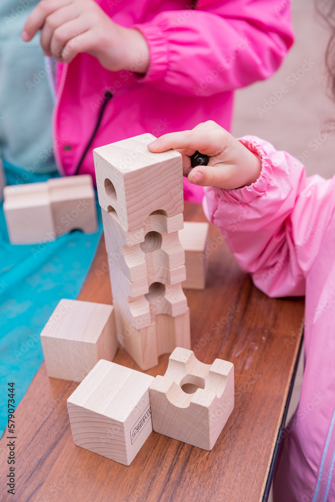 Little toddler plays with a wooden constructor, preschool child ...