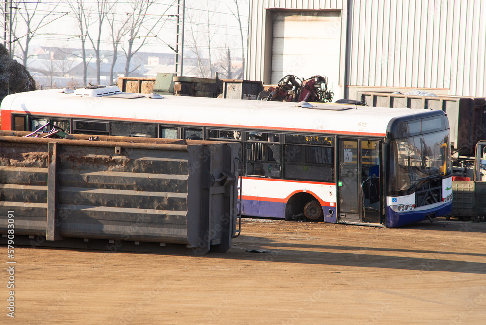 Wreck of damaged bus with broken windows and no wheels at a scrap-yard ...