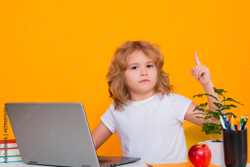 School child using laptop computer. School kid holding index finger up ...
