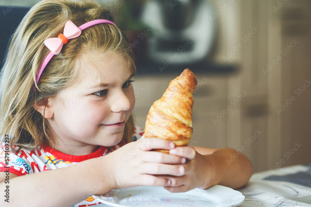 Smiling child at breakfast. Food and happy kids. The girl is eating a ...