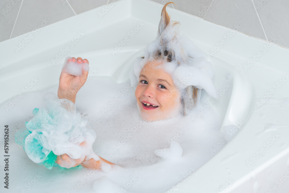 Foto de Kids shampoo. Kid in a bath tub. Washing in bath with soap suds ...