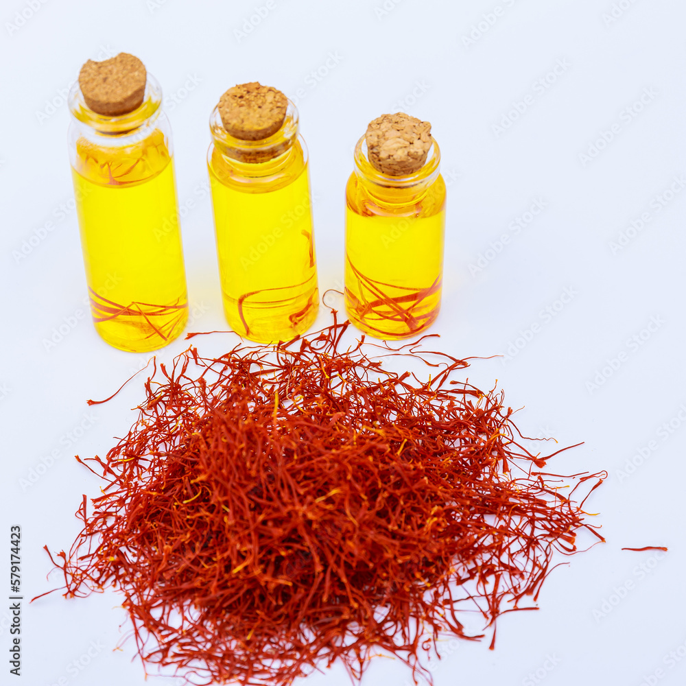A pile of dry saffron stamens and a serving of saffron drink in cans on ...