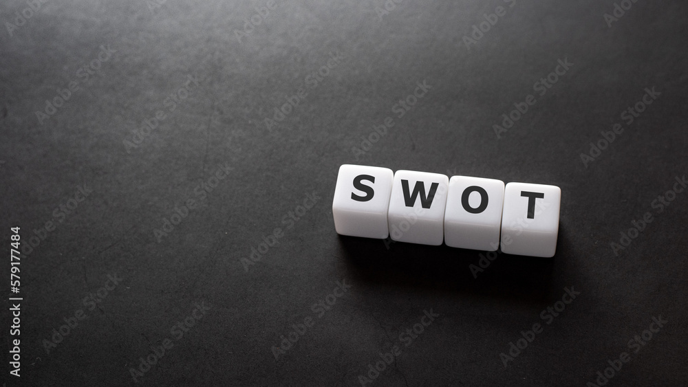 There is white cubes with the word SWOT. It is an acronym for strengths ...
