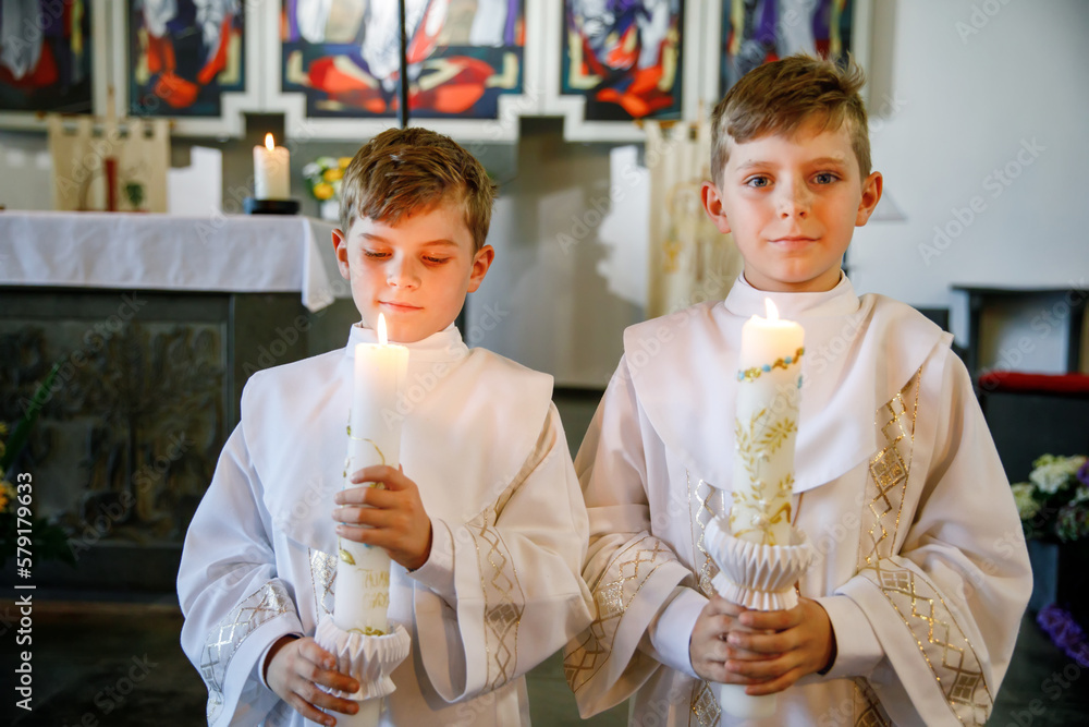 Two little kids boys receiving his first holy communion. Happy children ...