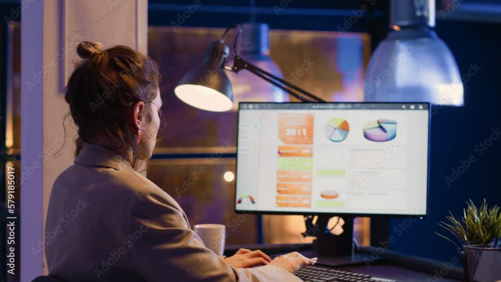 Office worker looking at computer running diagrams on screen, planning ...