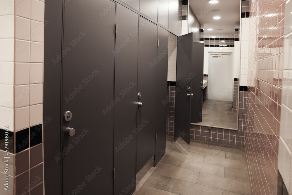 Public toilet interior with stalls and tiled walls Stock Photo | Adobe ...