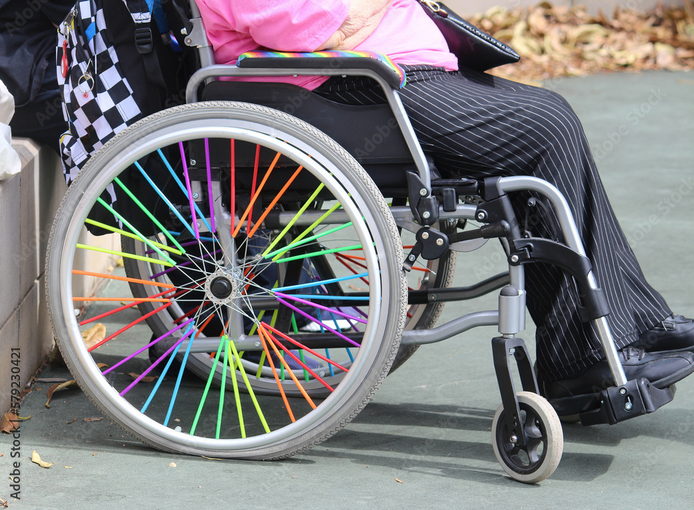 A disabled woman in a wheel chair. The wheelchair is decorated in ...