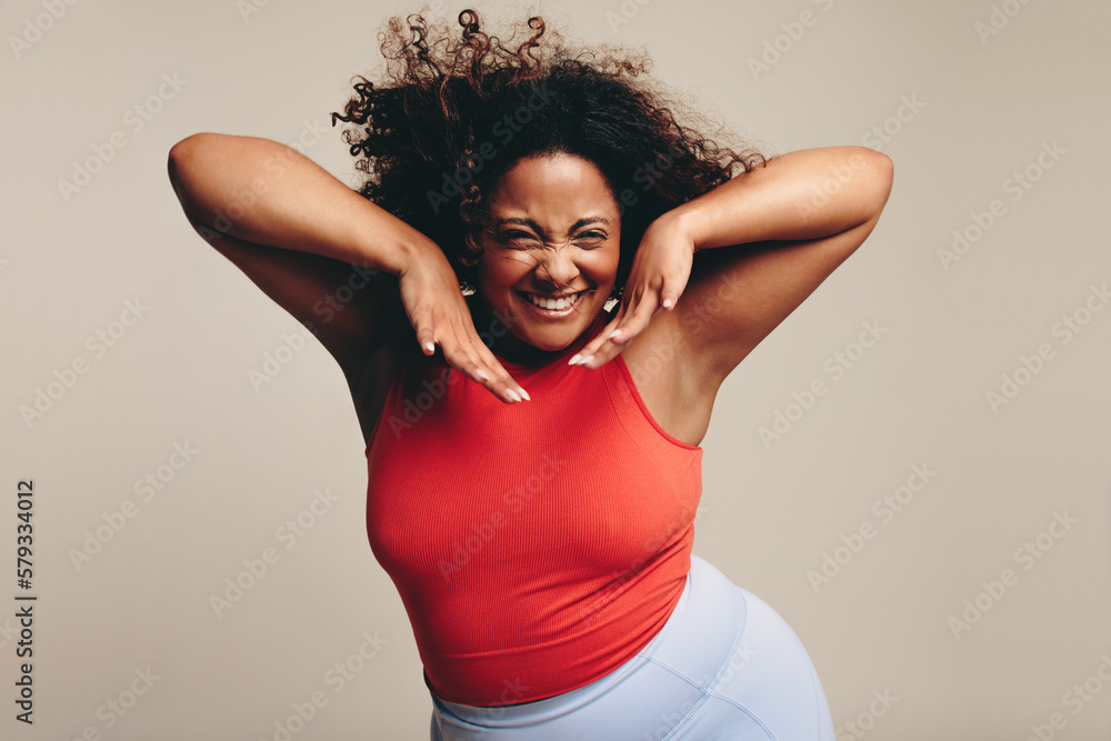 Excited woman moving her fit and curvy body in a fun dance workout ...