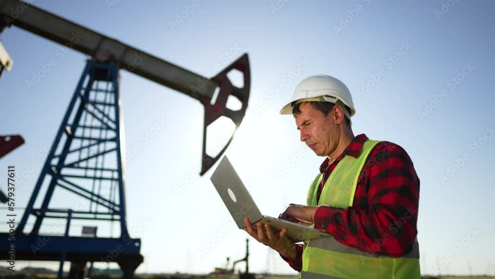 Oil pump.Engineer work with laptop and diagram.Checking operation of ...