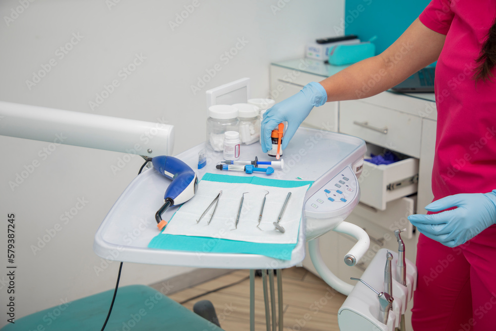 approaching the set of dental instruments, with the dentist's hands ...