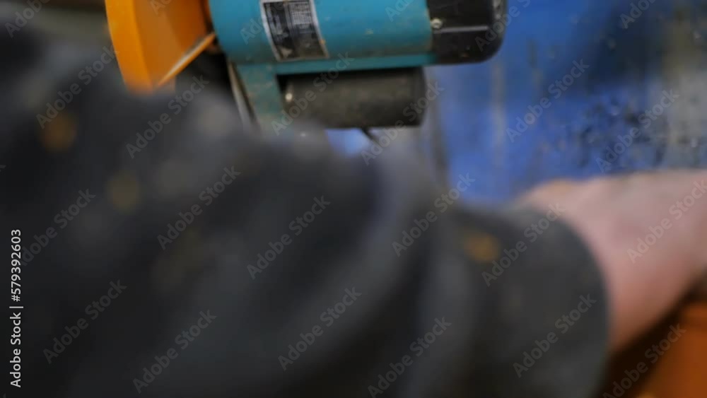 A worker's hands saw off segments from an orange pvc profile at ...