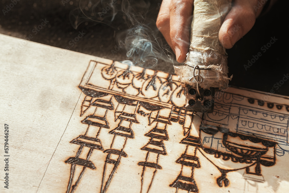 An artist using a pyrography tool to create a pyrogravure. Wood burning ...