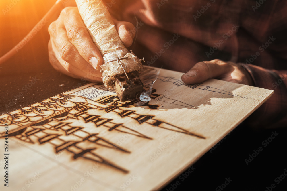 An artist using a pyrography tool to create a pyrogravure. Wood burning ...