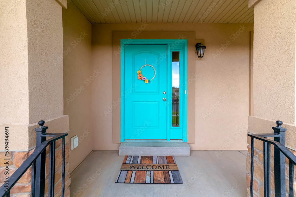 Cyan front door with flower wreath and sidelight with reflective glass ...