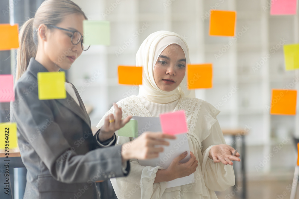 Young Asian woman Creative team use post it notes to share idea sticky ...