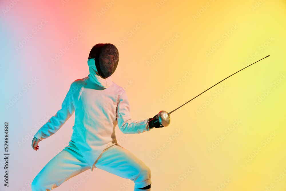 Young man, male fencer with sword practicing in fencing over gradient ...