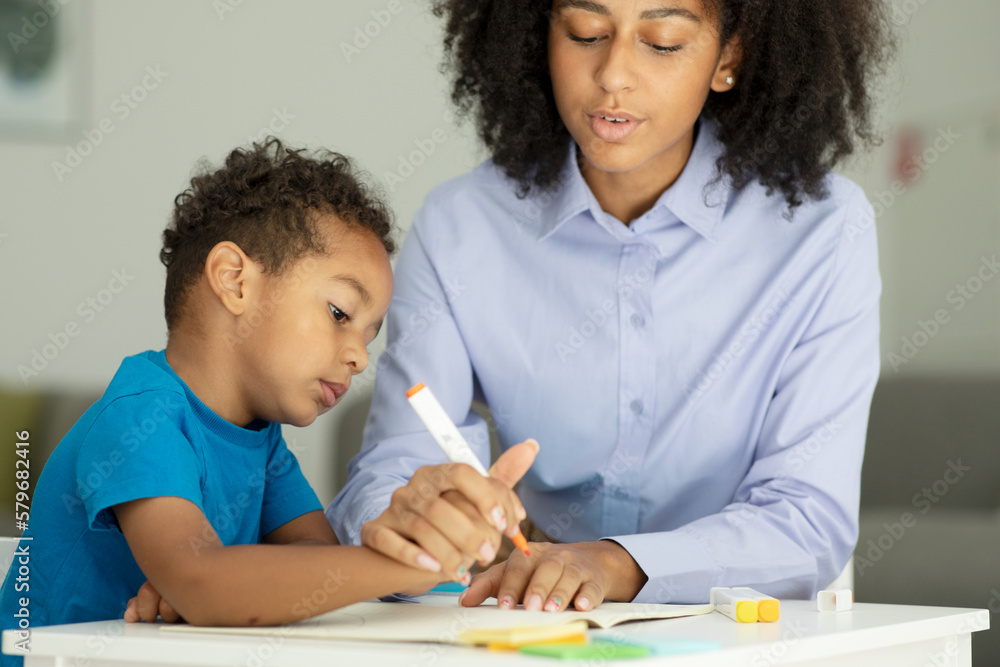 Foto de Female infant school teacher working one on one with a young ...