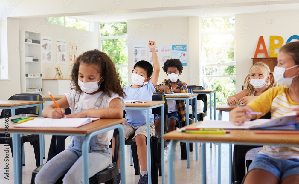 Young kids learning in classroom after covid pandemic, wearing ...