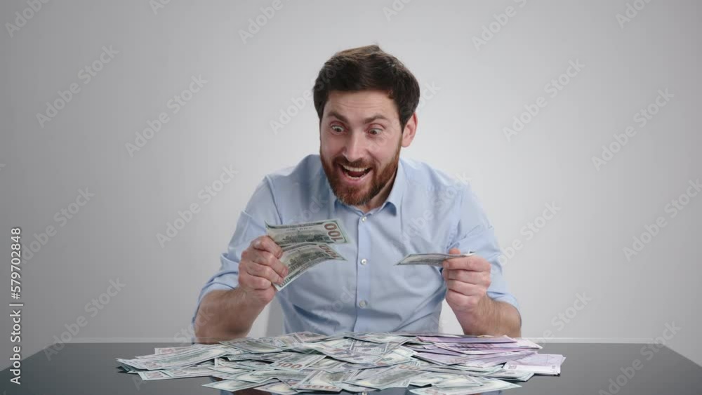Vidéo Stock A man in a blue shirt smelling and grabbing money from a ...