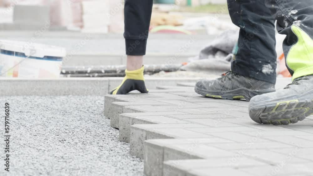 laying interlocking pavers during the construction of sidewalks and ...