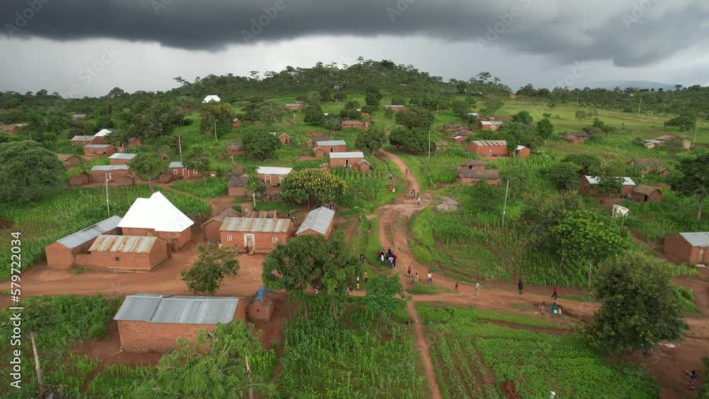 Rural village in Africa. Mud huts and agricultural land. Local people ...