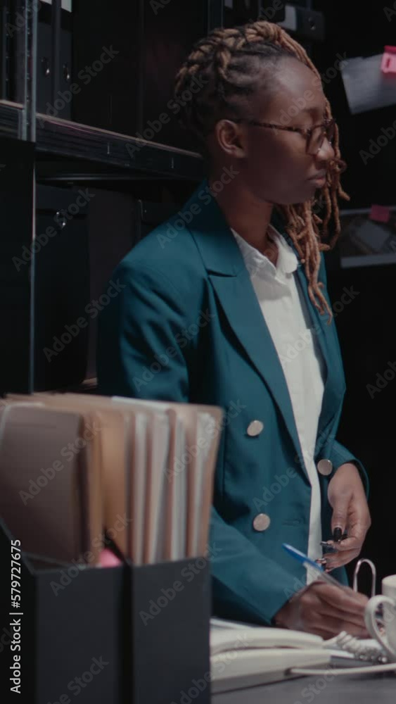 Vertical video: African american agents reading statements reports in ...