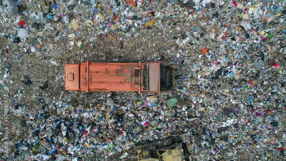 Aerial top down view of truck unloading garbage, waste at landfill ...