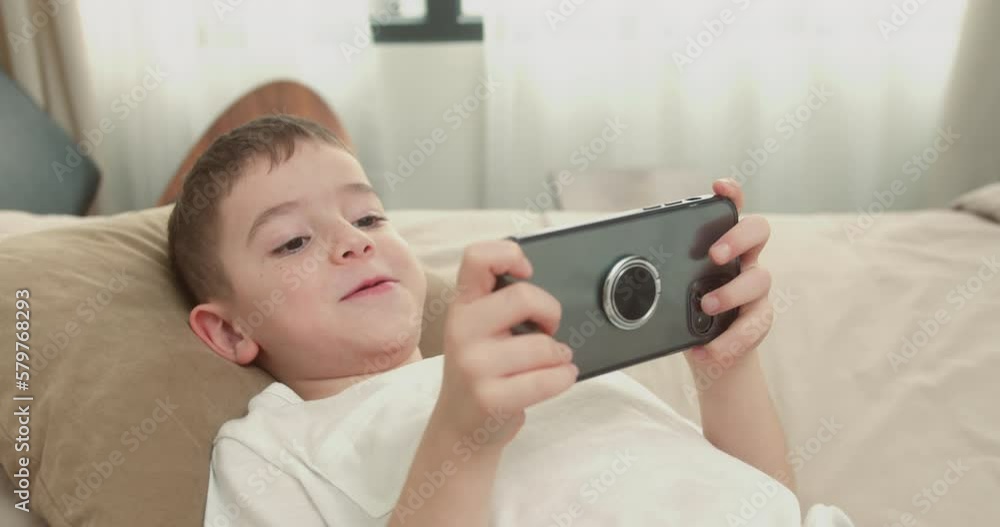 Child playing video game indoors. Beautiful child boy 6 years old ...
