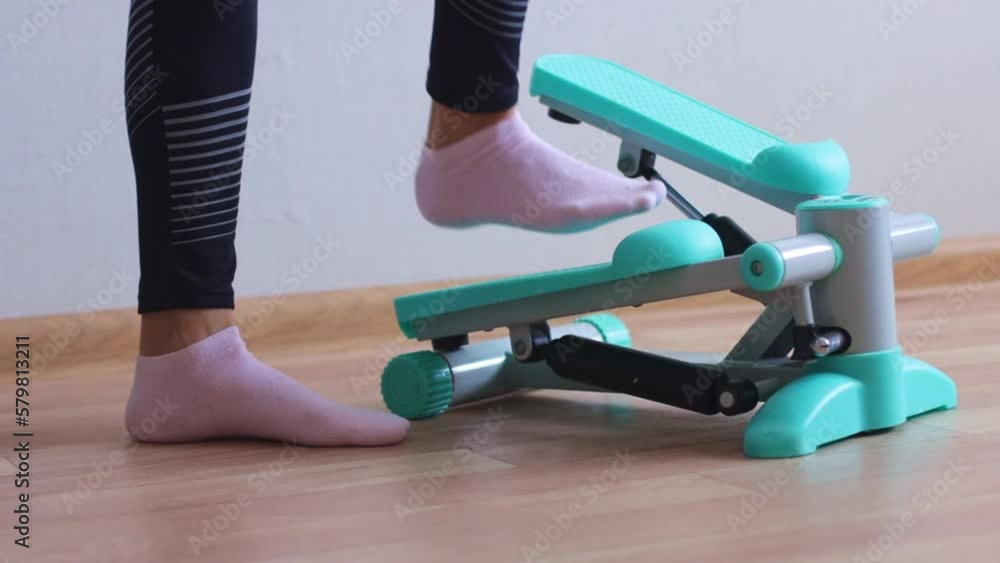 Exercises, cardio training with stepper at home. Woman trains on ...