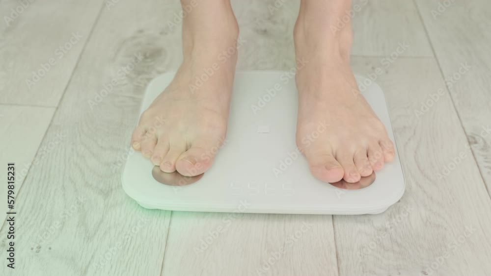 Vídeo do Stock: Legs of young girl standing on scale to measure weight ...