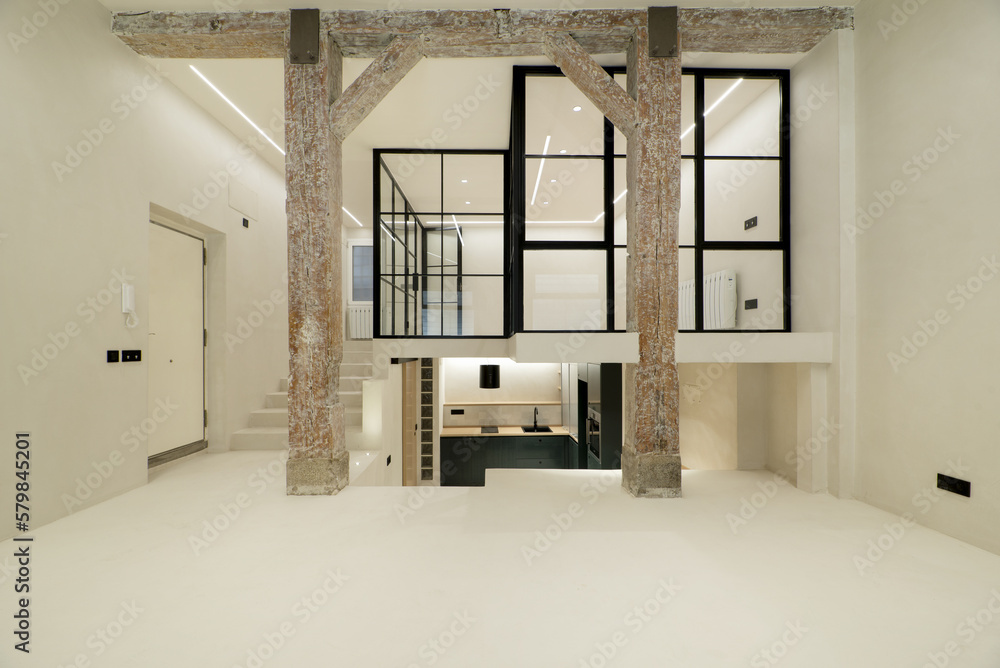 Empty loft with exposed brick walls, other white walls and a room with ...
