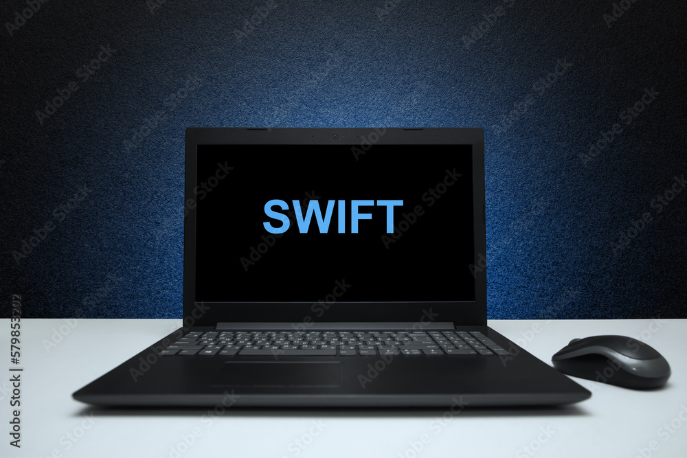 Swift text on laptop screen on textured black background with blue ...