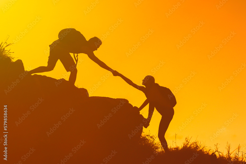 Hikers helping each other climb up a mountain working as a teem Stock ...