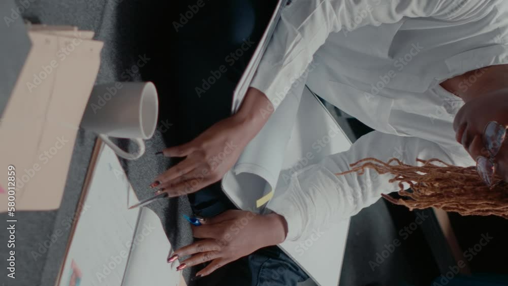 Vertical video: Female inspector reading information on case files ...