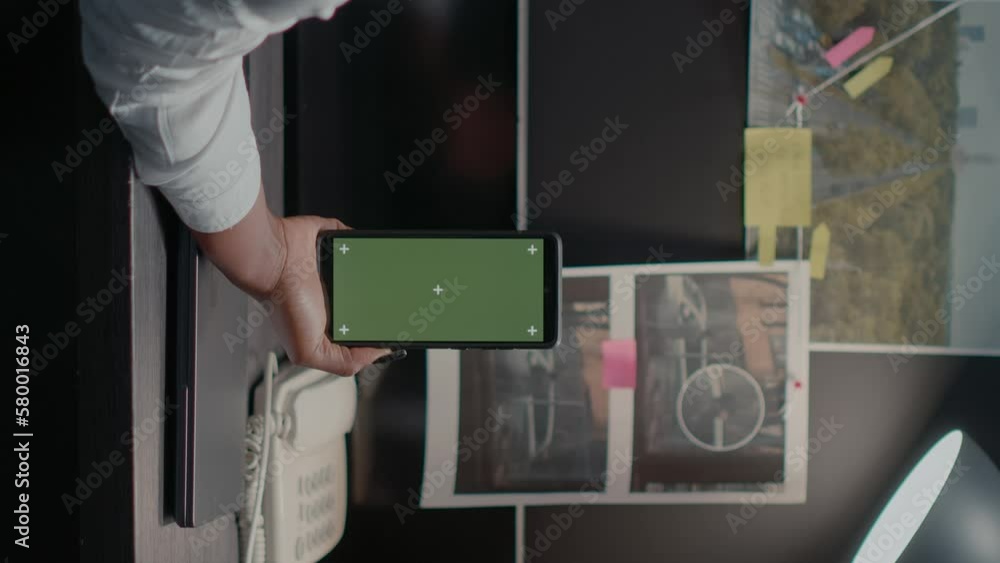 Vertical video: Law officer holding mobile pohne with greenscreen ...