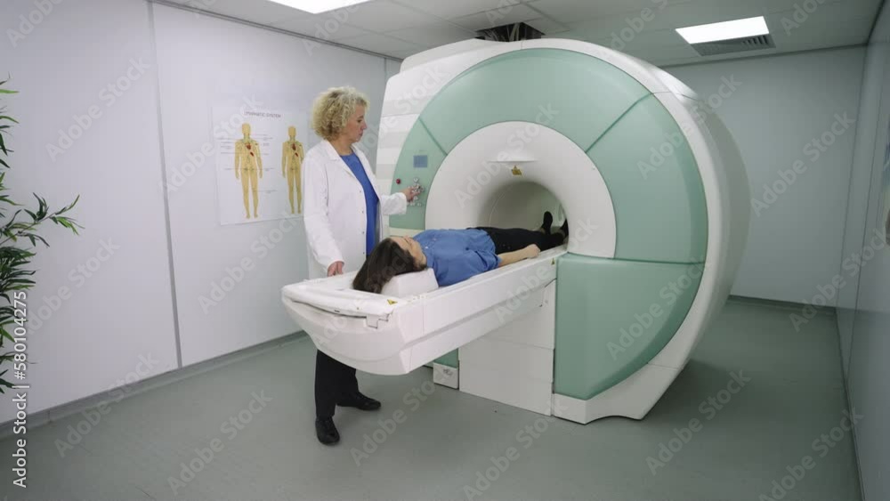 Patient having MRI scanning procedure in modern clinic lying on scanner ...