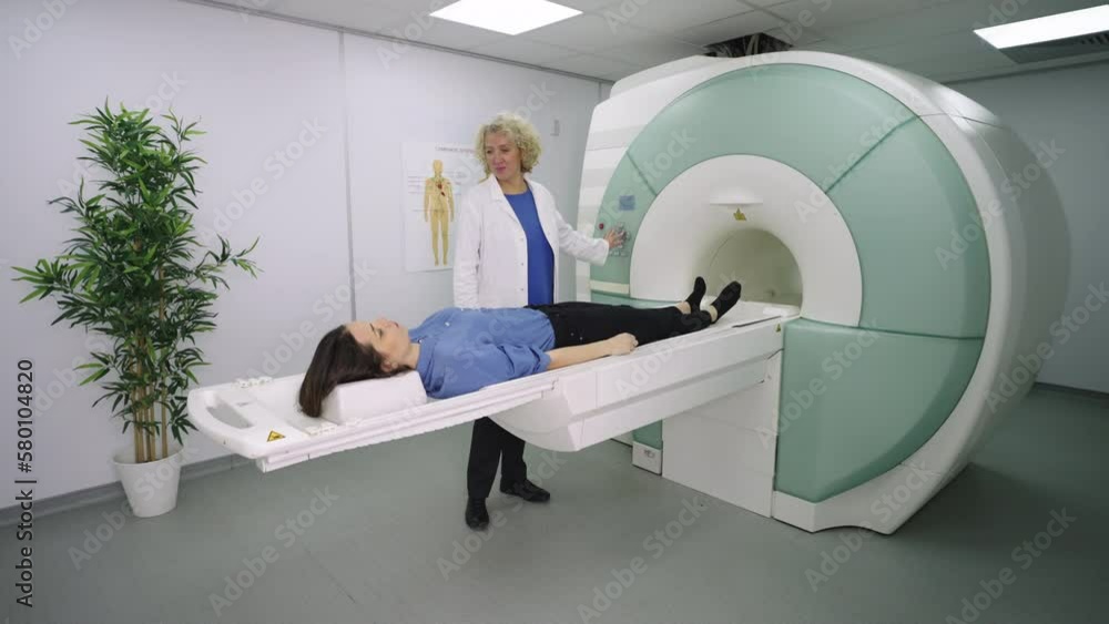 Medical technical assistant performing radiological scan of patient ...