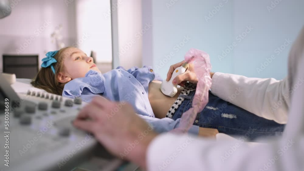 Cute little girl lying in clinic, having ultrasound procedure of ...
